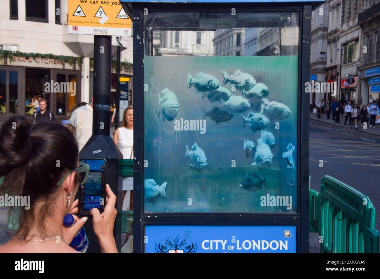 London, UK. 12th August 2024. A woman takes a photo of the new Banksy ...
