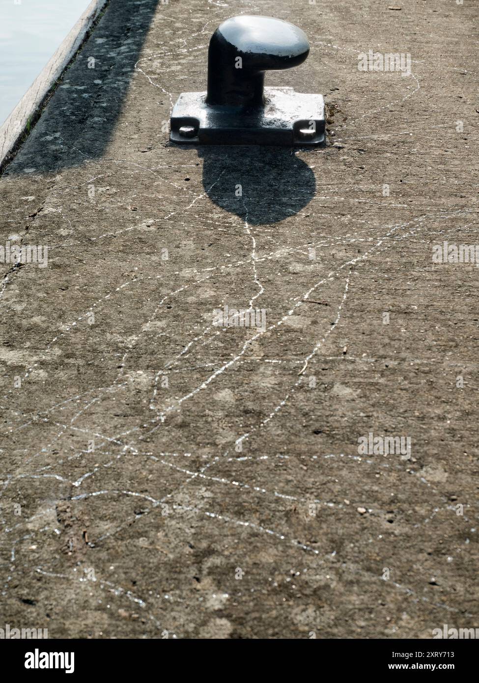 Mooring post and slug tracks by the Thames. Close-up of mooring post by ...