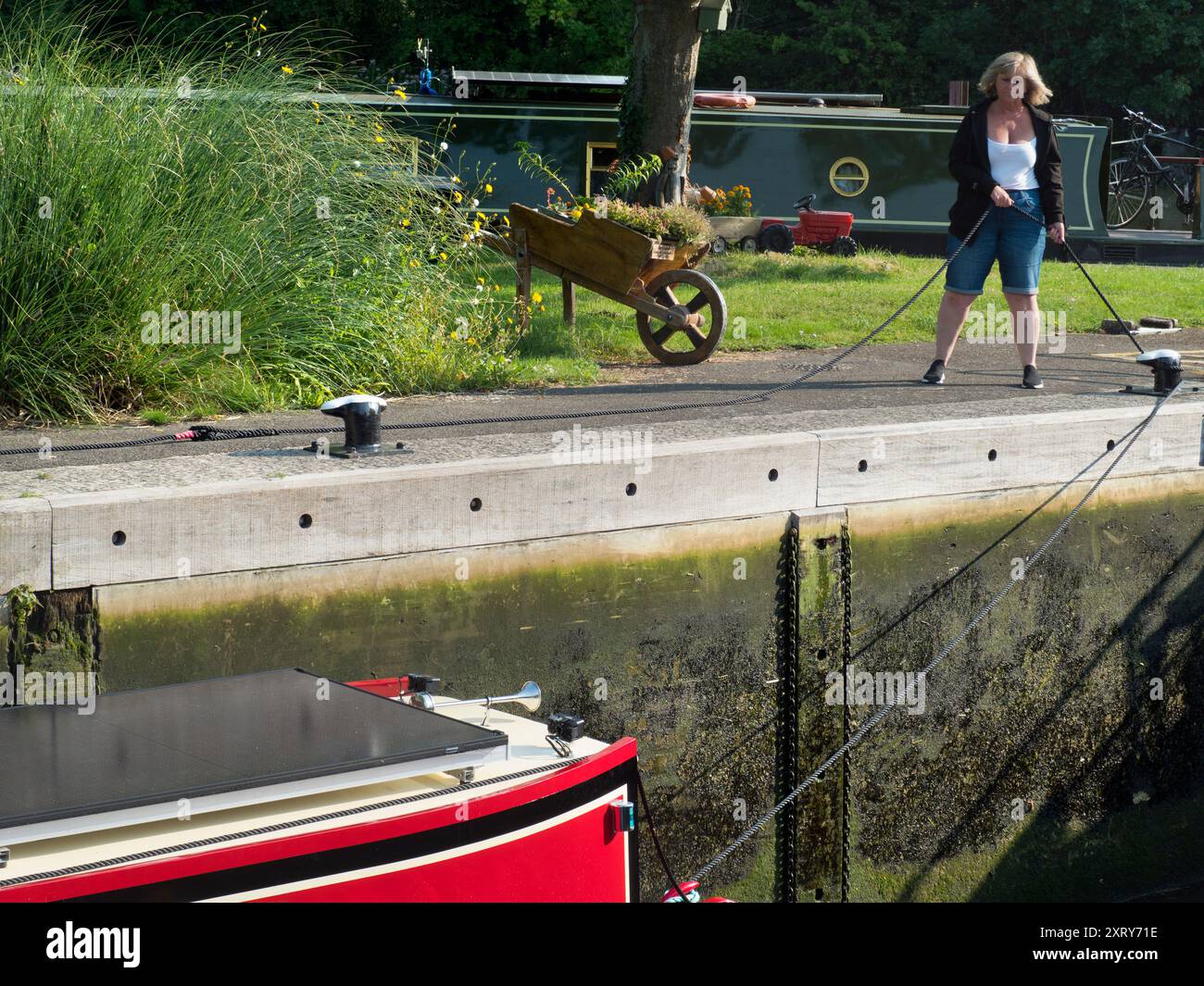 Woman securing a houseboat between the gates of Abingdon Lock on the ...