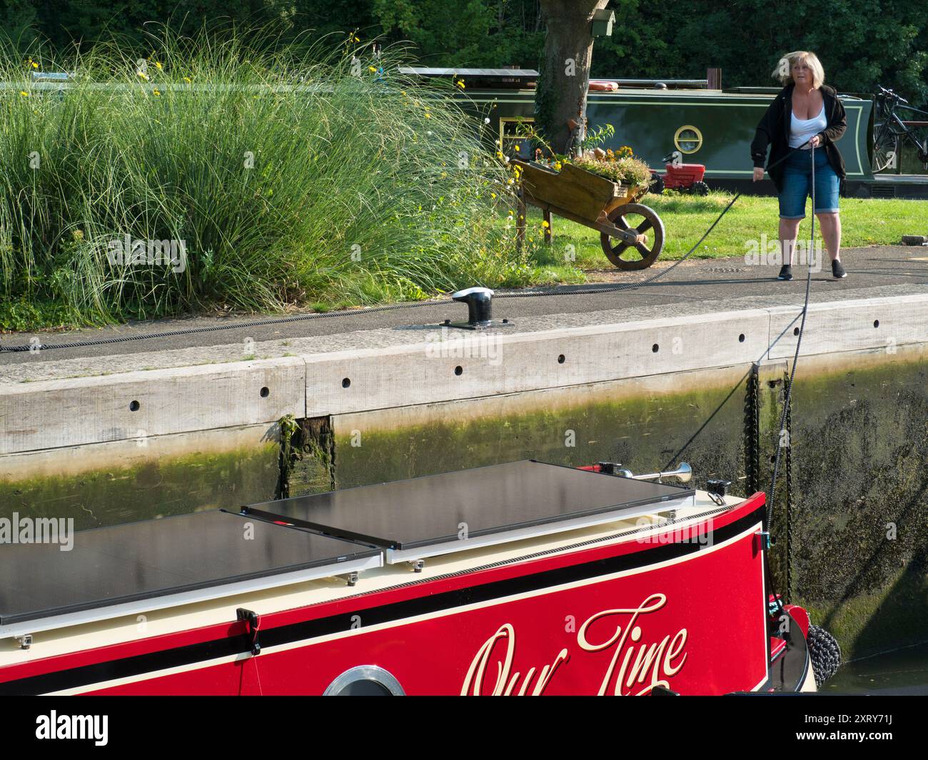 Woman securing a houseboat between the gates of Abingdon Lock on the ...