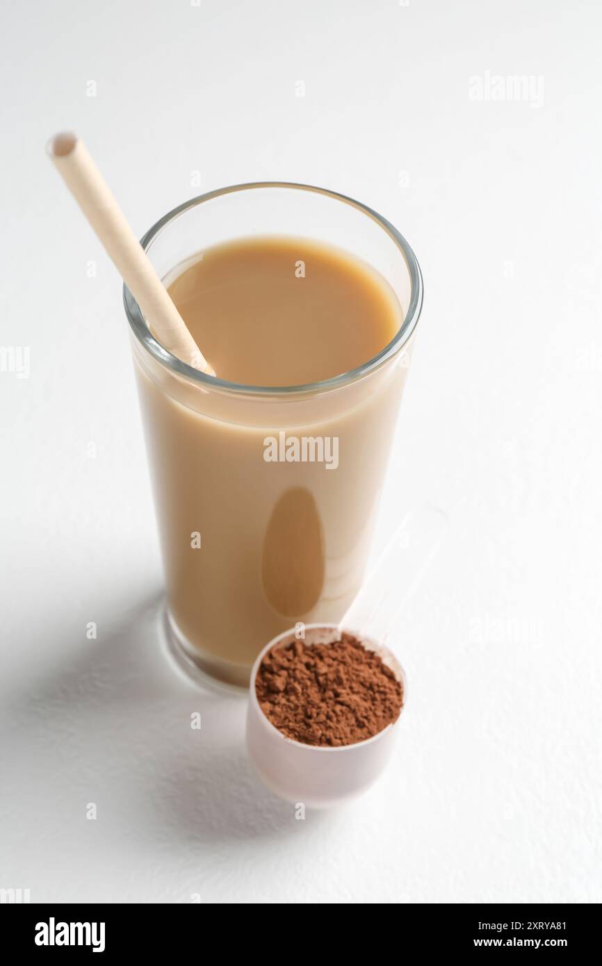 Delicious protein shake in glass and scoop with powder on white ...