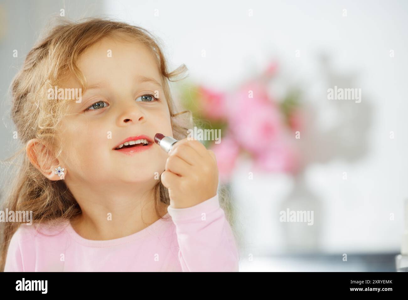 Child enjoys putting on lipstick, mimic grown-up makeup rituals Stock ...