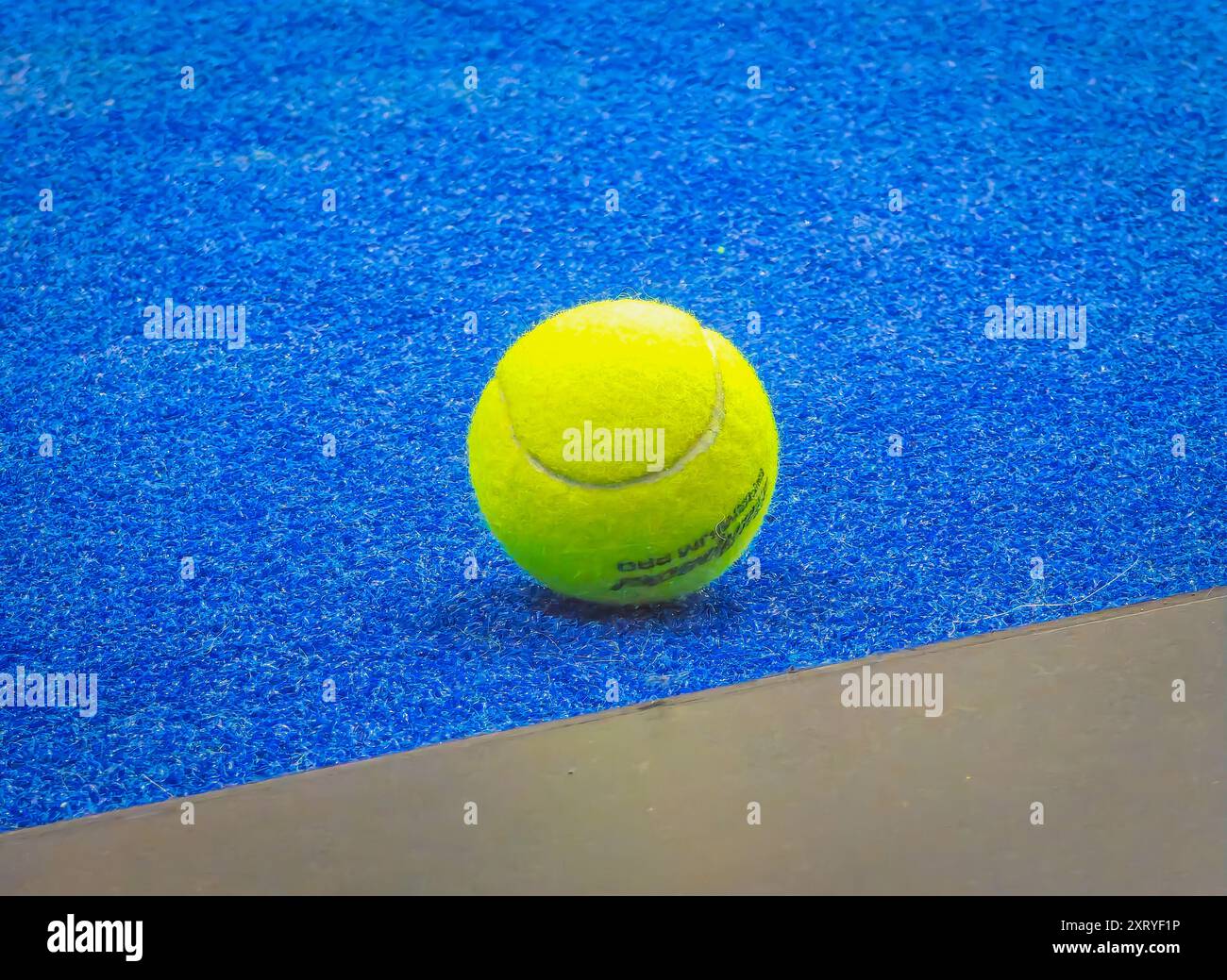 Padel tennis ball on the blue carpet in the court. Close up photo Stock ...