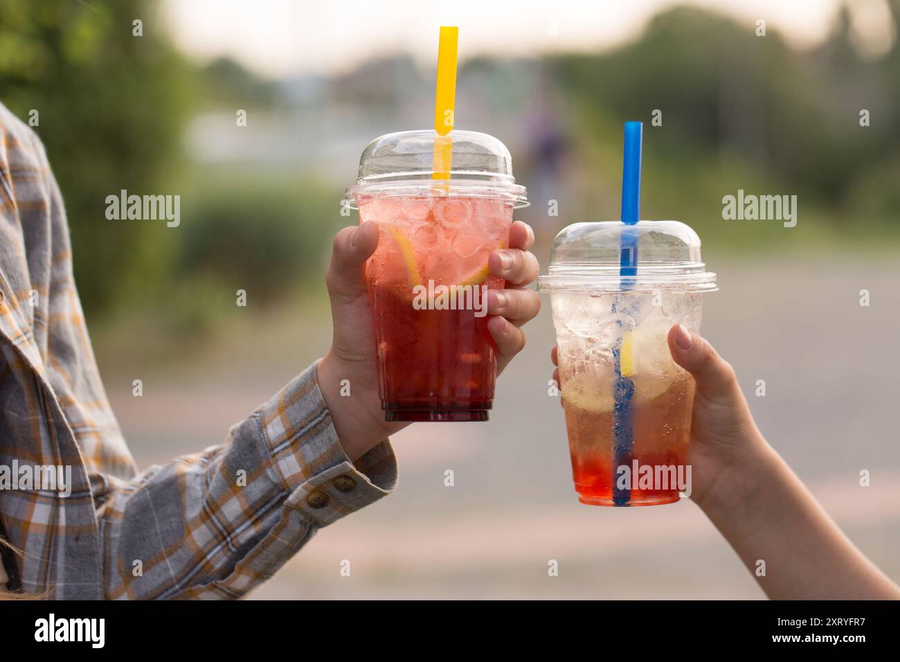 Two children drink bubble tea from plastic cups on a walk in the ...