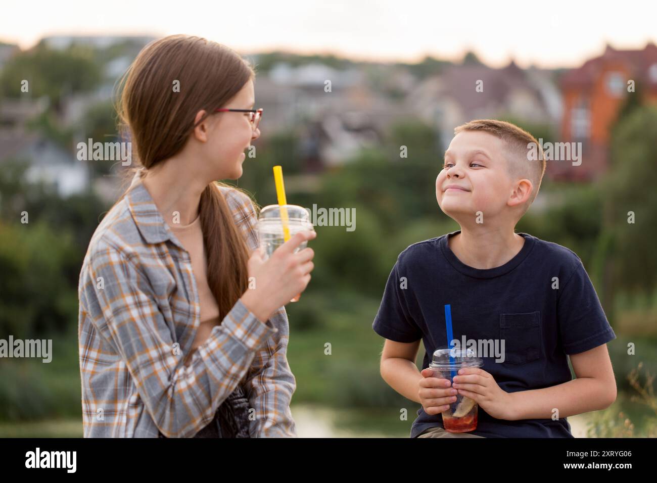 Two children drink bubble tea from plastic cups on a walk in the ...