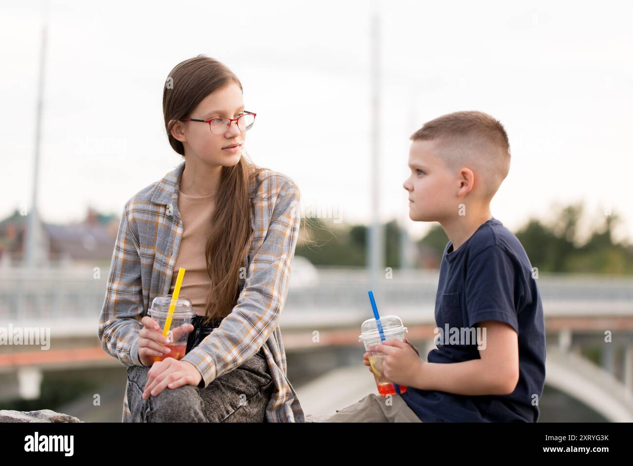 Two children drink bubble tea from plastic cups on a walk in the ...