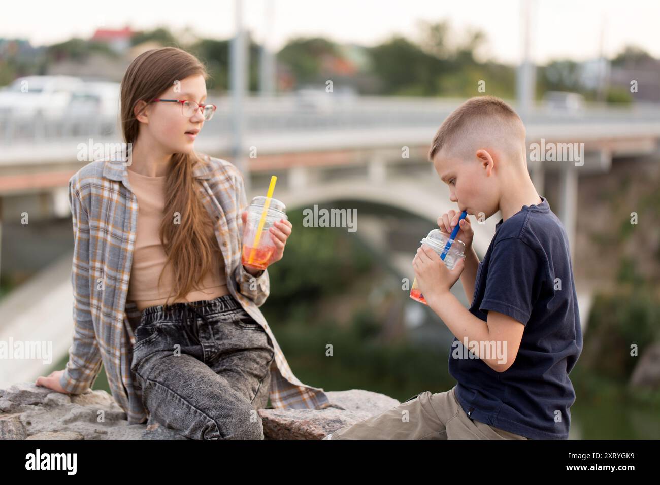 Two children drink bubble tea from plastic cups on a walk in the ...