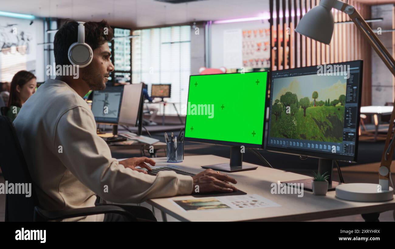 Indian Male Game Designer Using Desktop Computer With Green Screen ...
