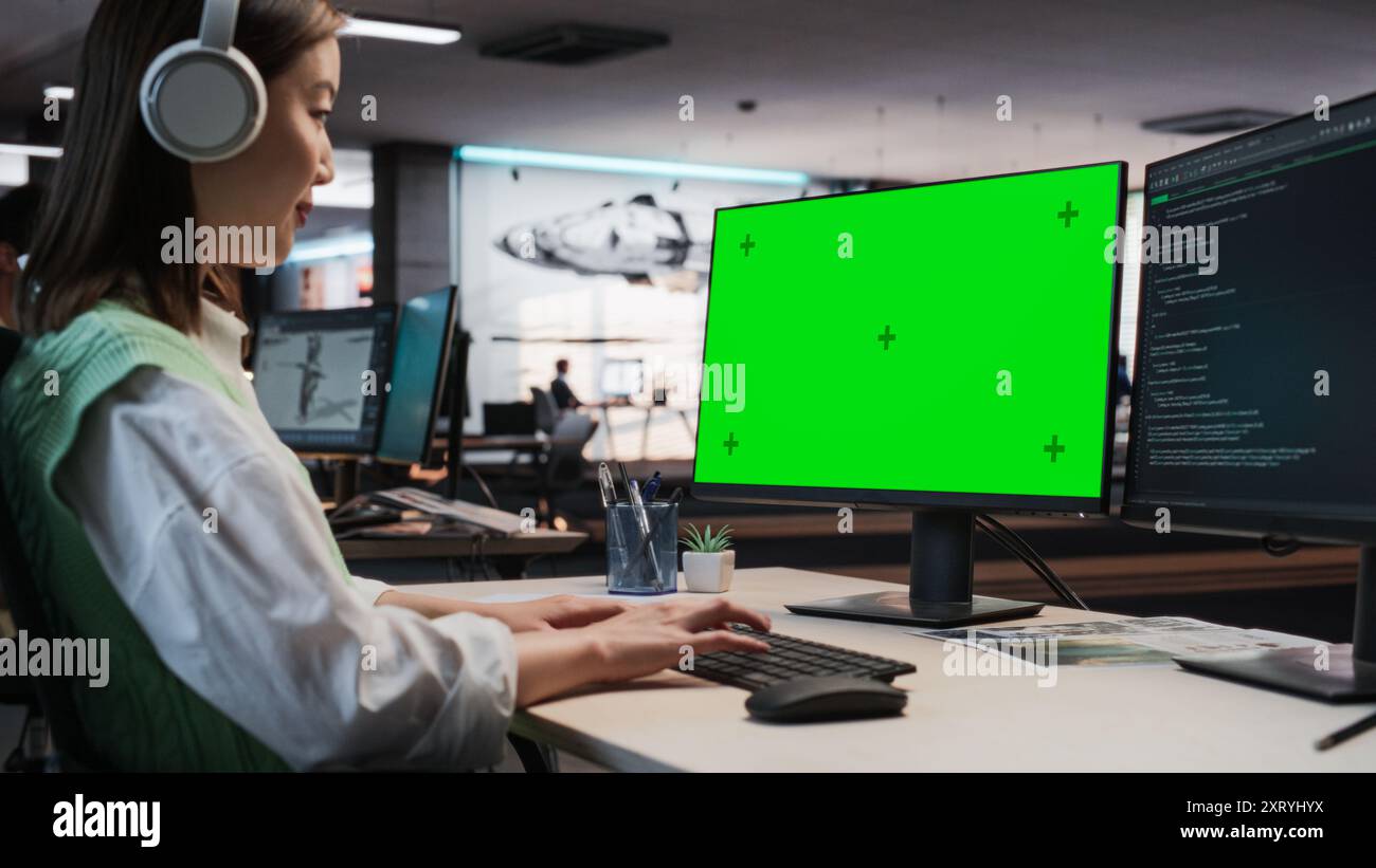 Female Asian Game Programmer Coding On Desktop Computer With Green Screen Chromakey On Display ...