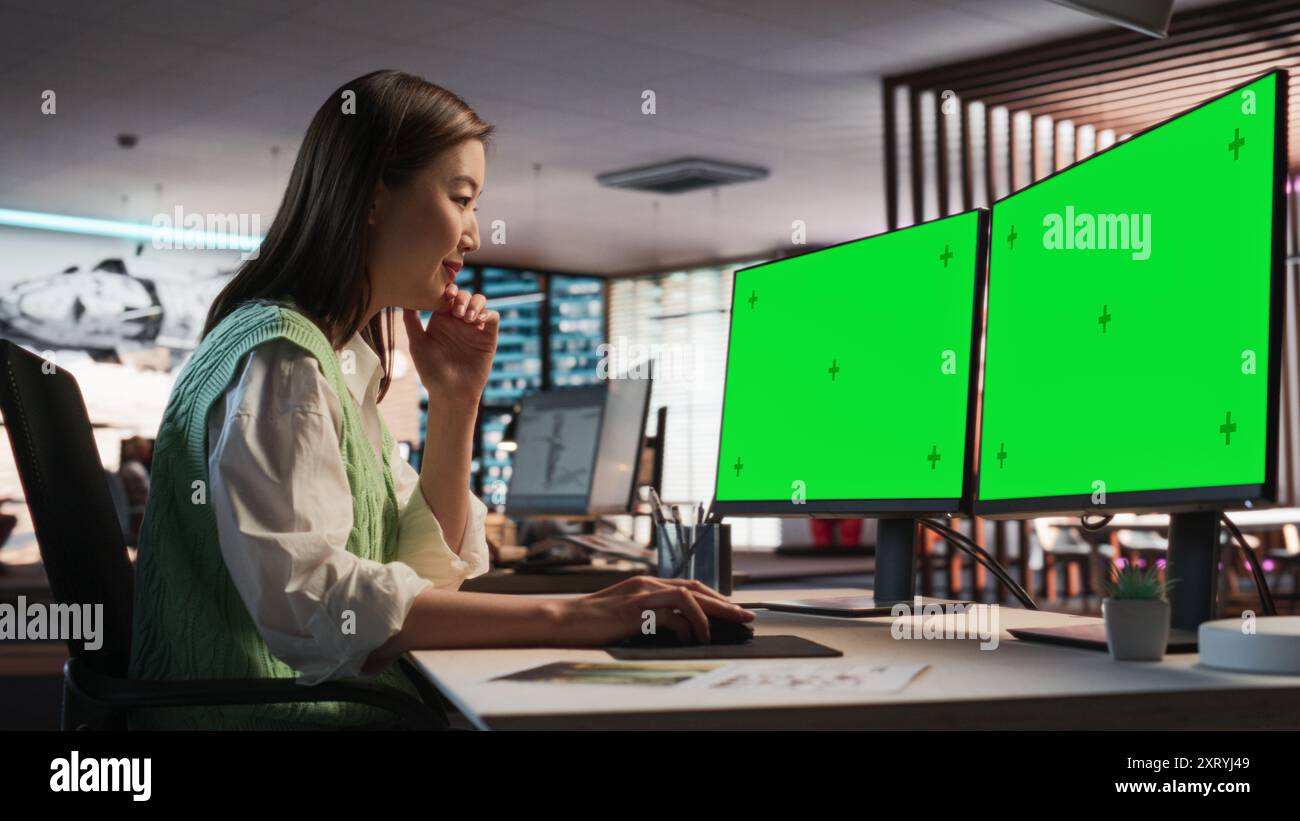 Female Asian Game Designer Using Desktop Computer With Green Screen Chromakey on Display ...