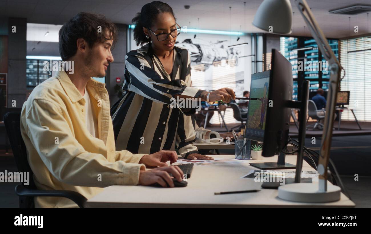 Caucasian Male Game Designer Using Desktop Computer With 3d Modelling Software And Talking To