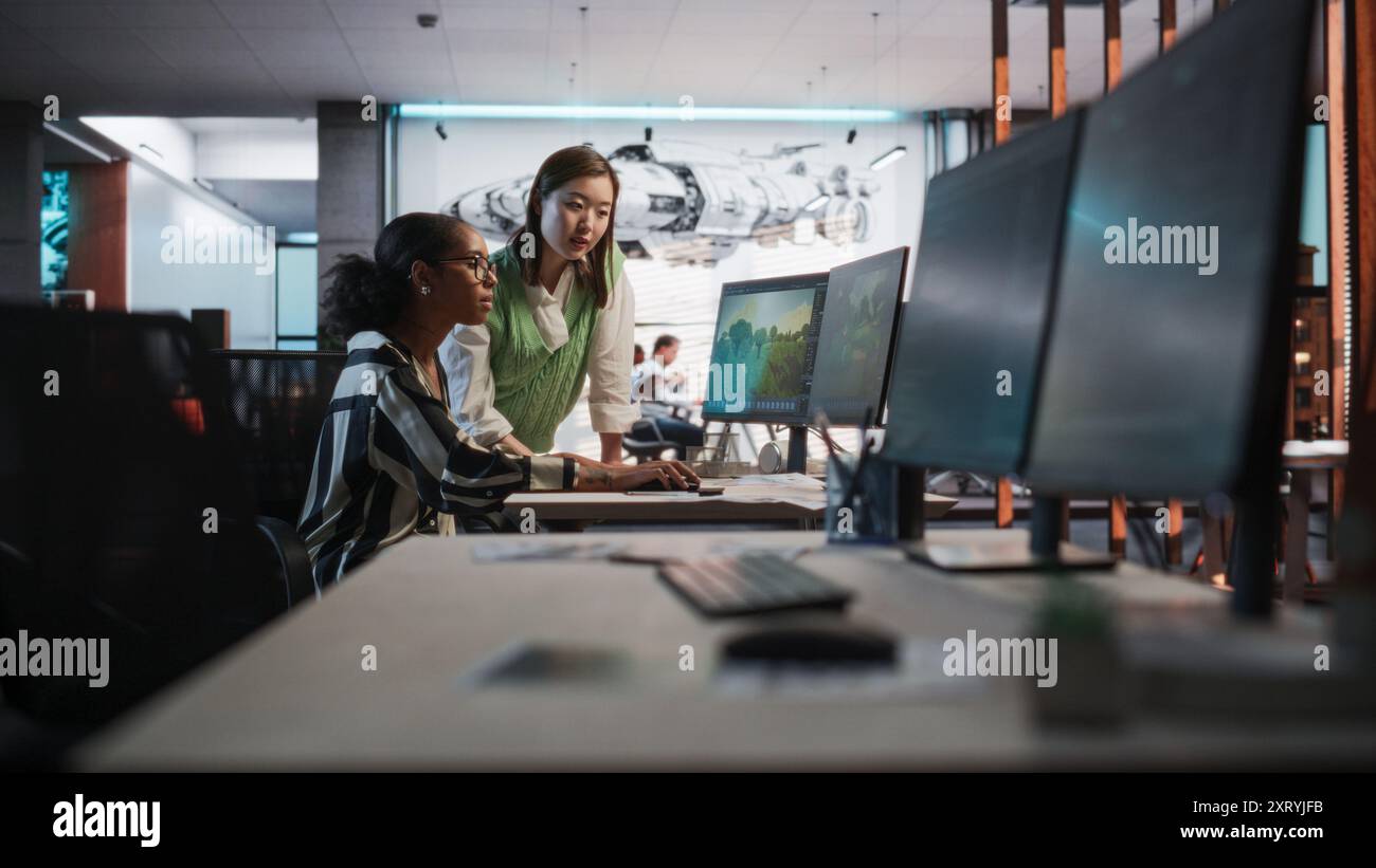 Black Female Game Developer Using Desktop Computer With 3d Modelling Software And Talking To