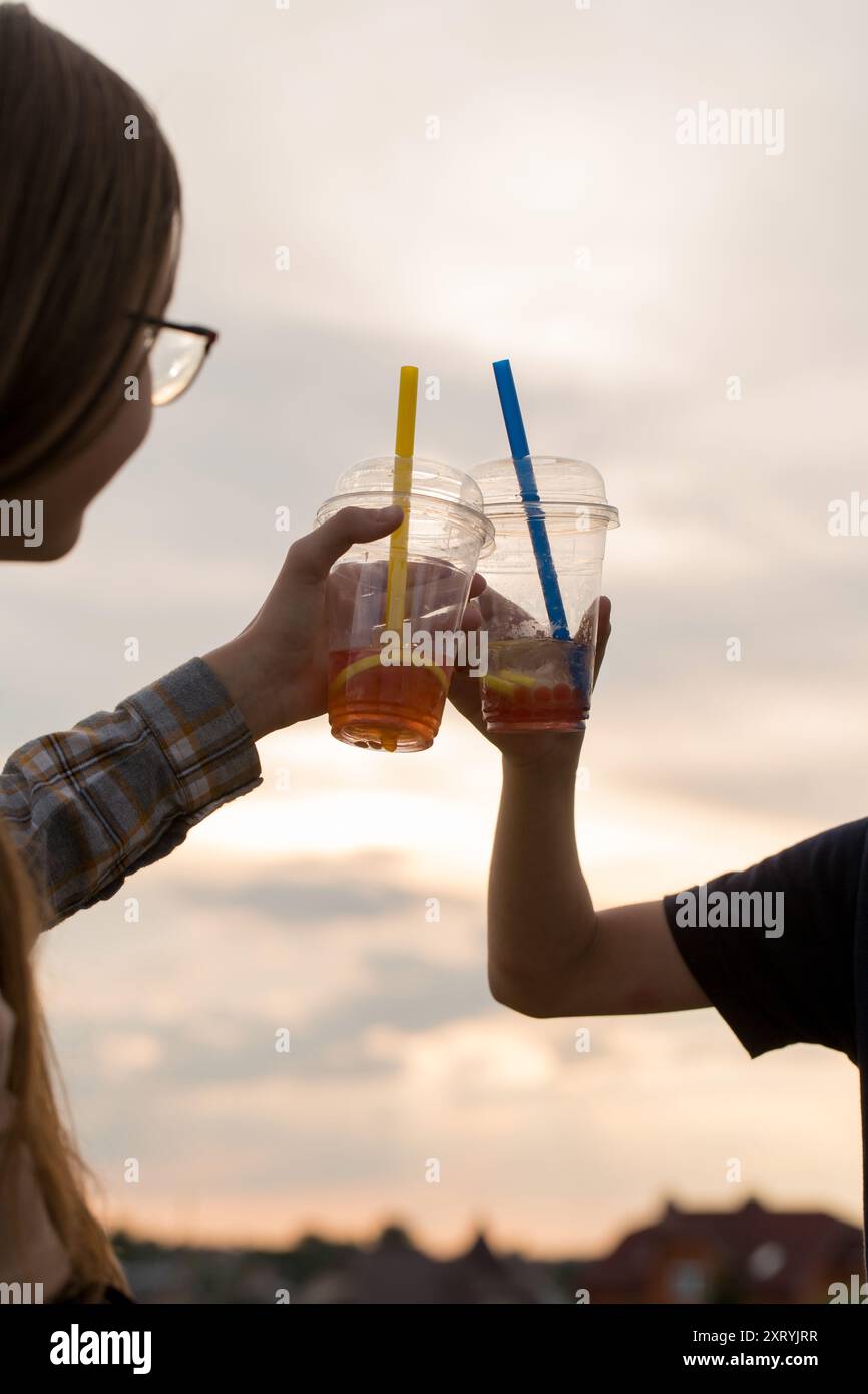 Two children drink bubble tea from plastic cups on a walk in the ...