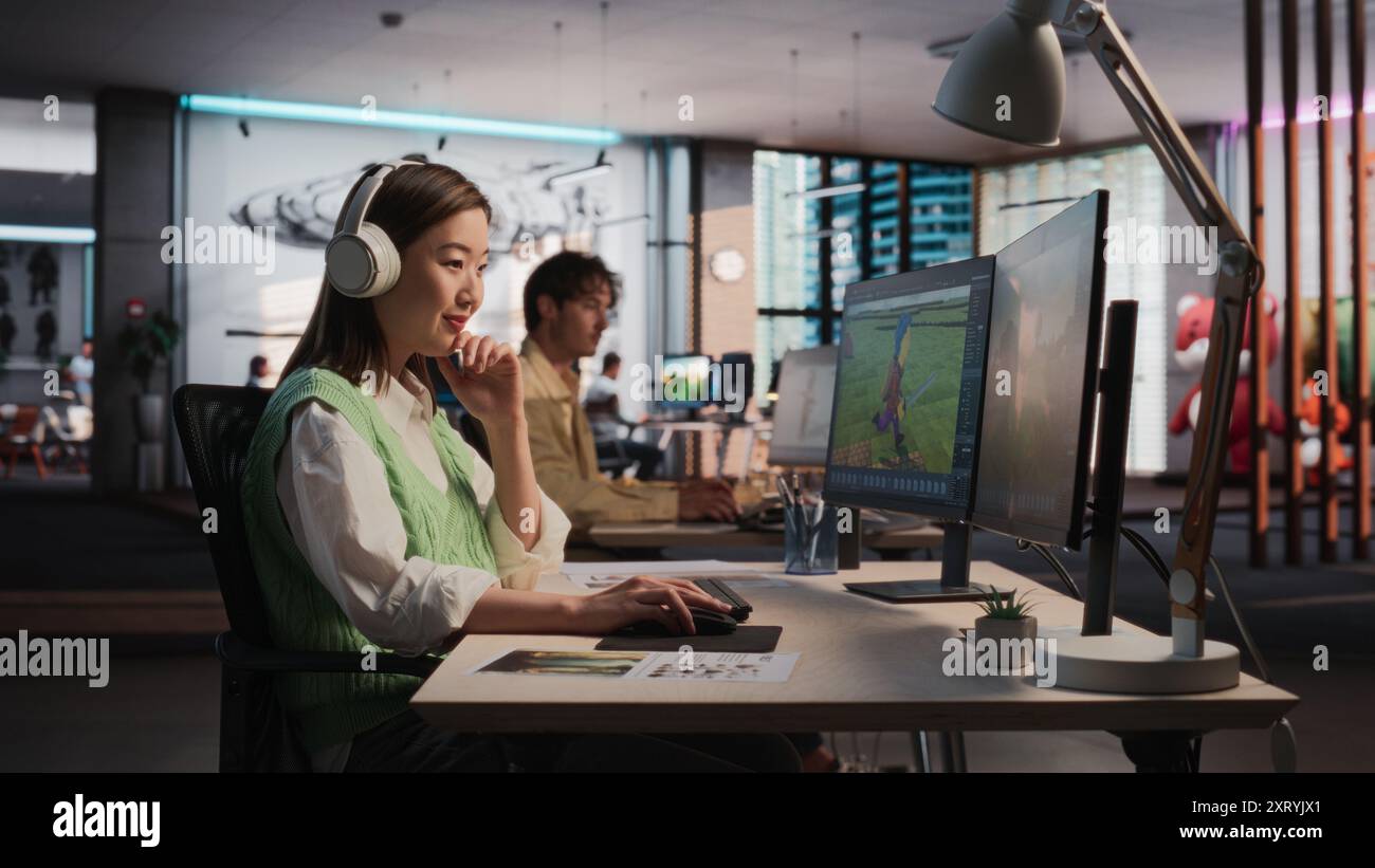 Female Asian Game Designer Using Desktop Computer Designing Unique World And Characters In 3d