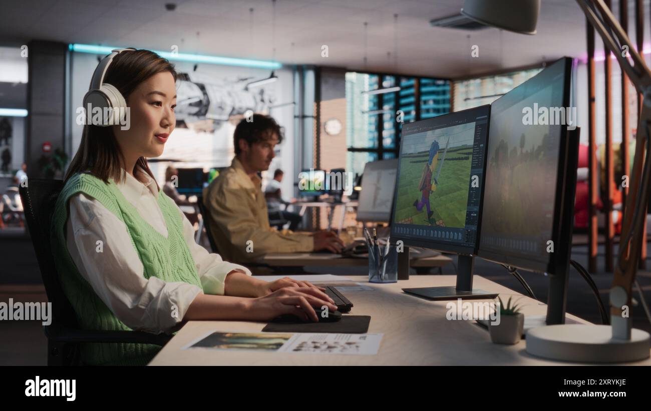 Female Asian Game Designer Using Desktop Computer Designing Unique World And Characters In 3d