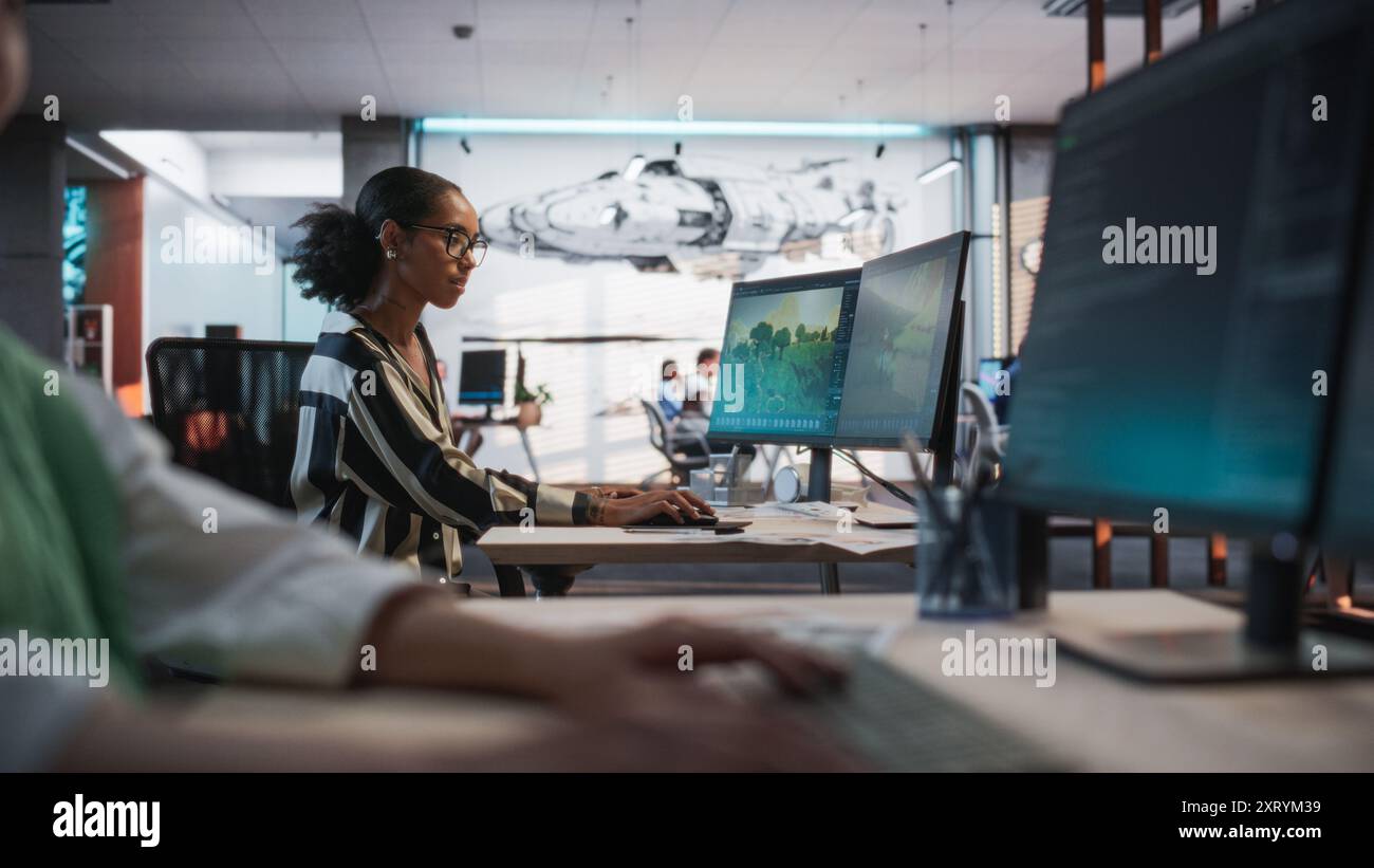Black Female Game Developer Using Desktop Computer With 3D modelling Software And Talking to ...