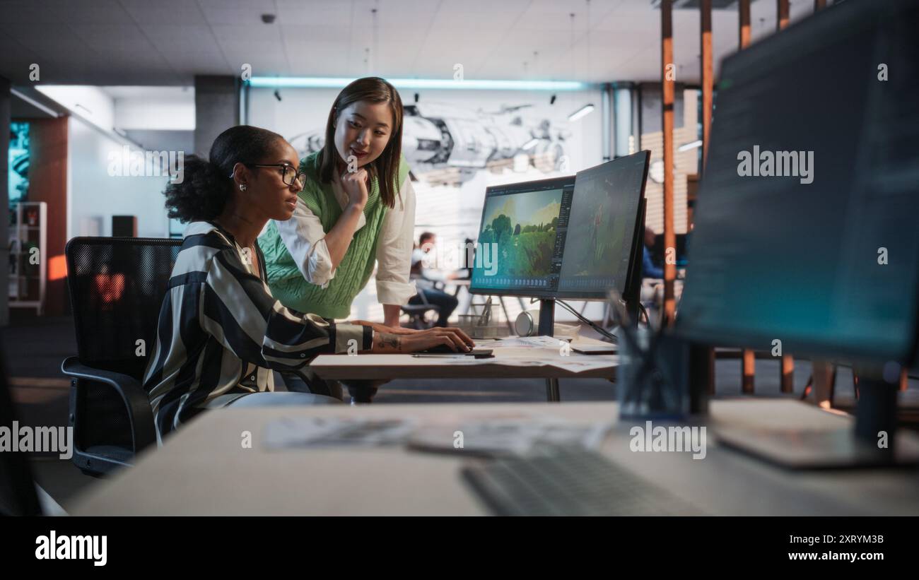 Black Female Game Designer Using Desktop Computer With 3d Modelling Software And Talking To