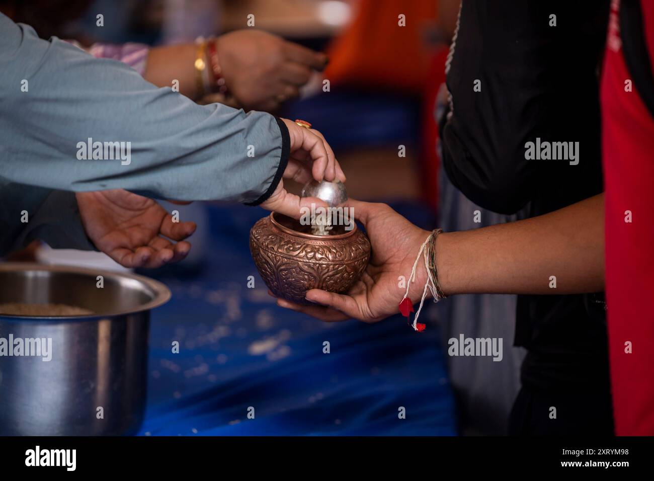 Lalitpur, Nepal. 12th Aug, 2024. An offering is distributed during the ...