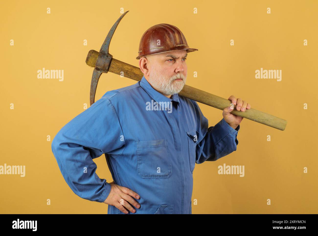 Serious bricklayer in hard hat with pickaxe. Bearded construction ...
