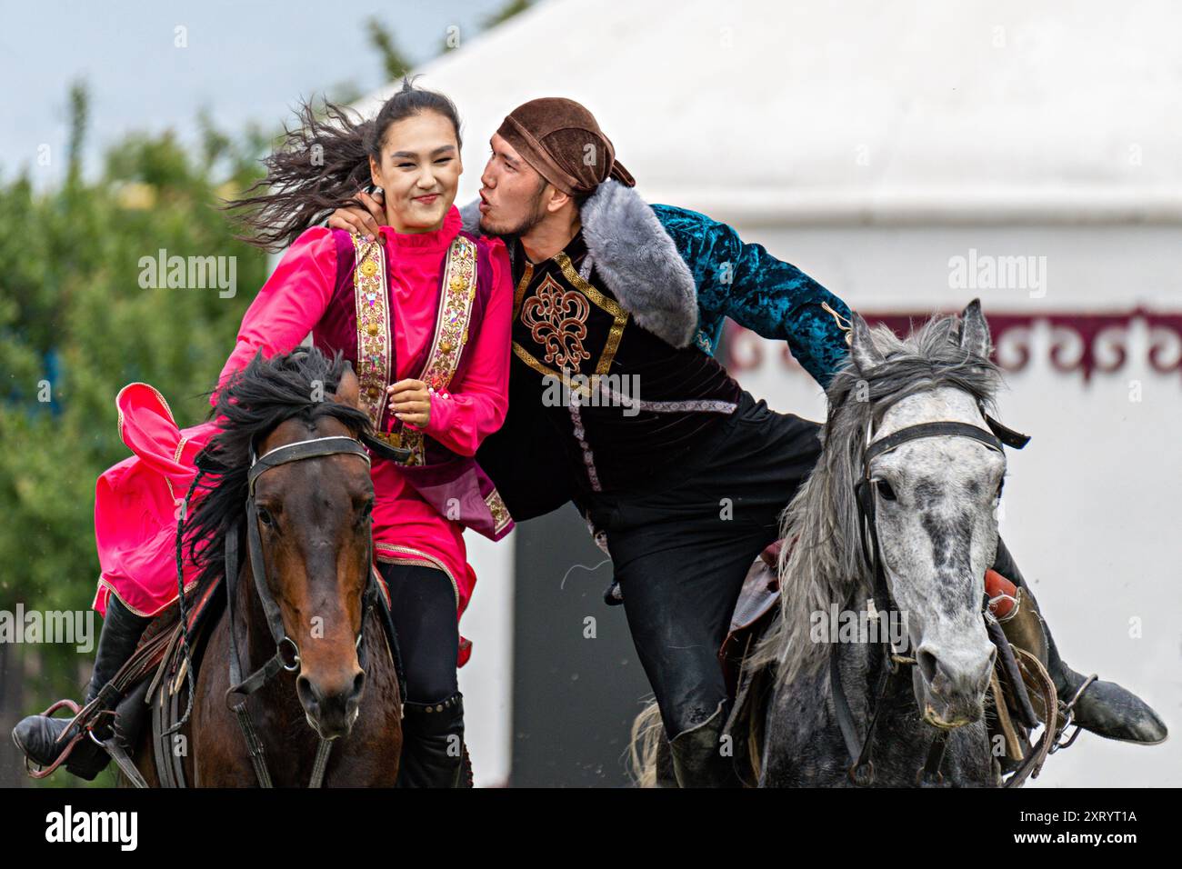 Nomadic man on his horse trying to kiss the woman in local dress on her ...