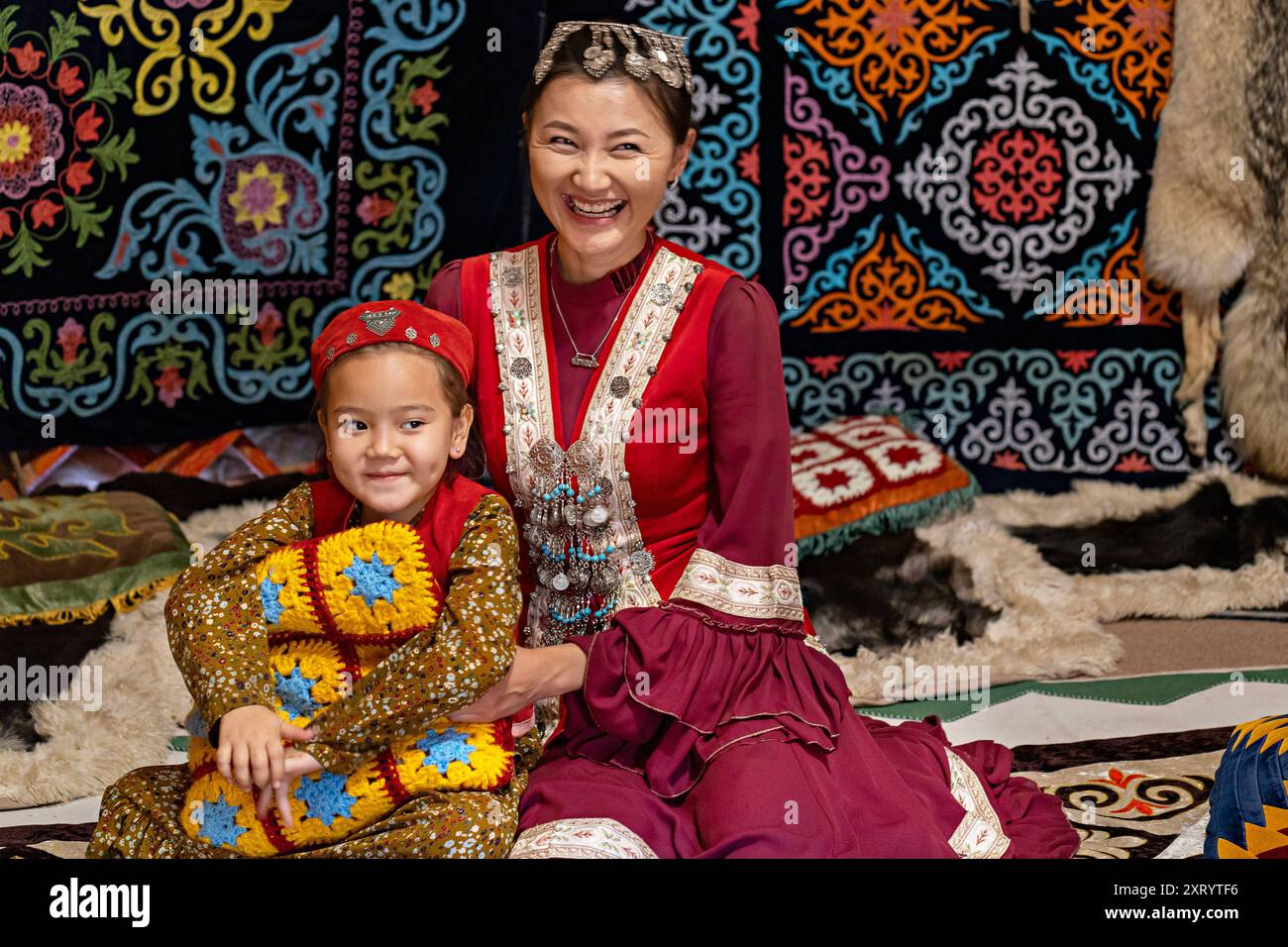 Nomadic woman and child in traditional dress inside a decorated yurt in ...