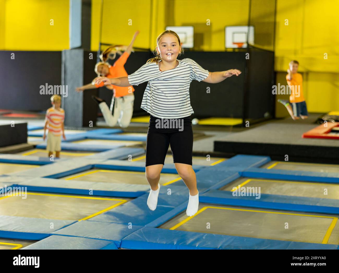Tween girl bouncing on trampoline in indoor amusement park Stock Photo ...