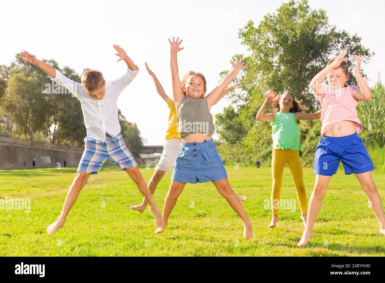 Kids jumping and raising hands Stock Photo - Alamy