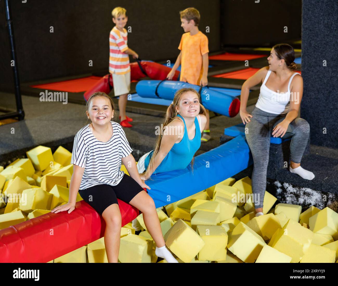 Happy tween girls sitting on soft beam above foam pit Stock Photo - Alamy