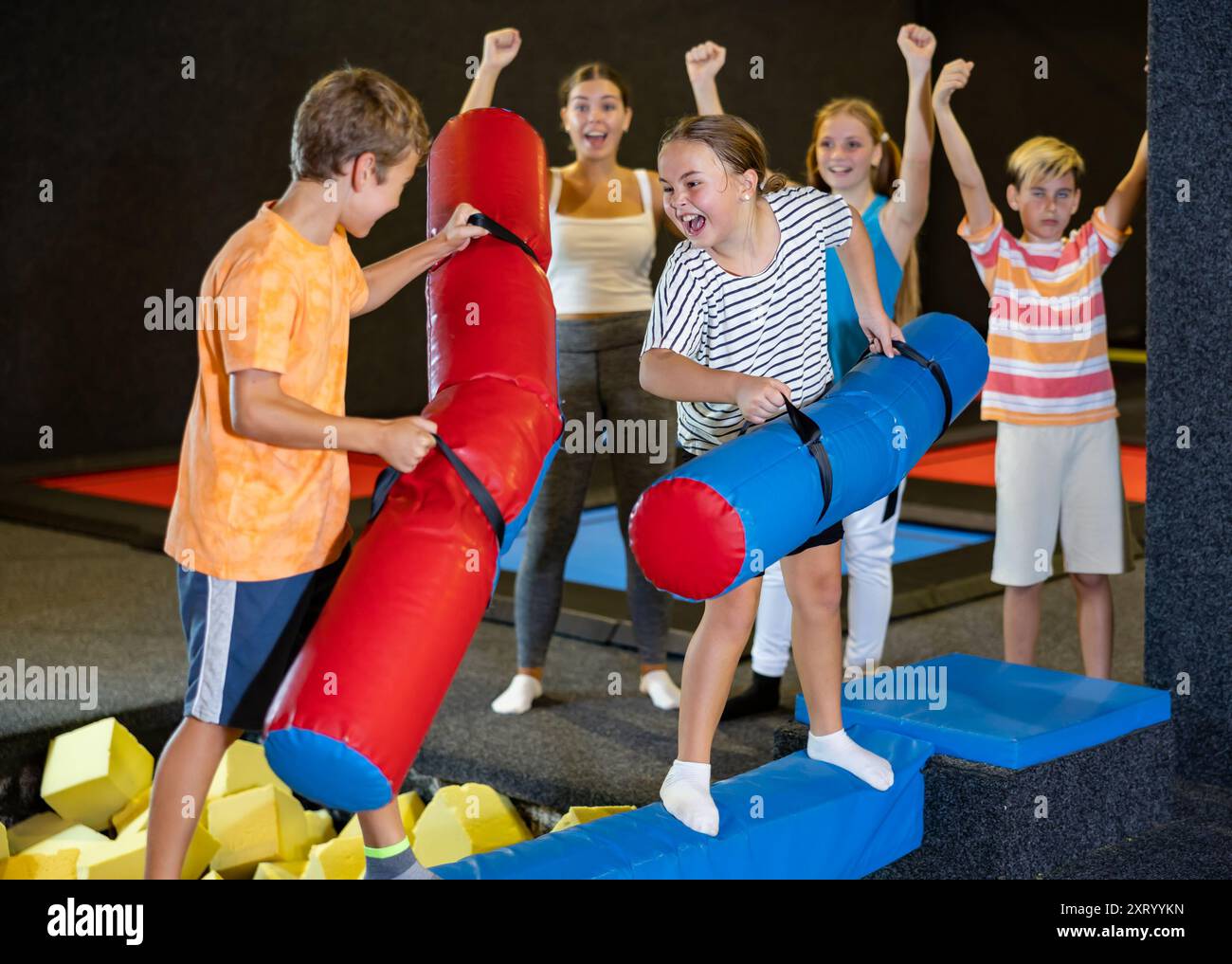 Tween girl having fun on battle beam with friend Stock Photo - Alamy