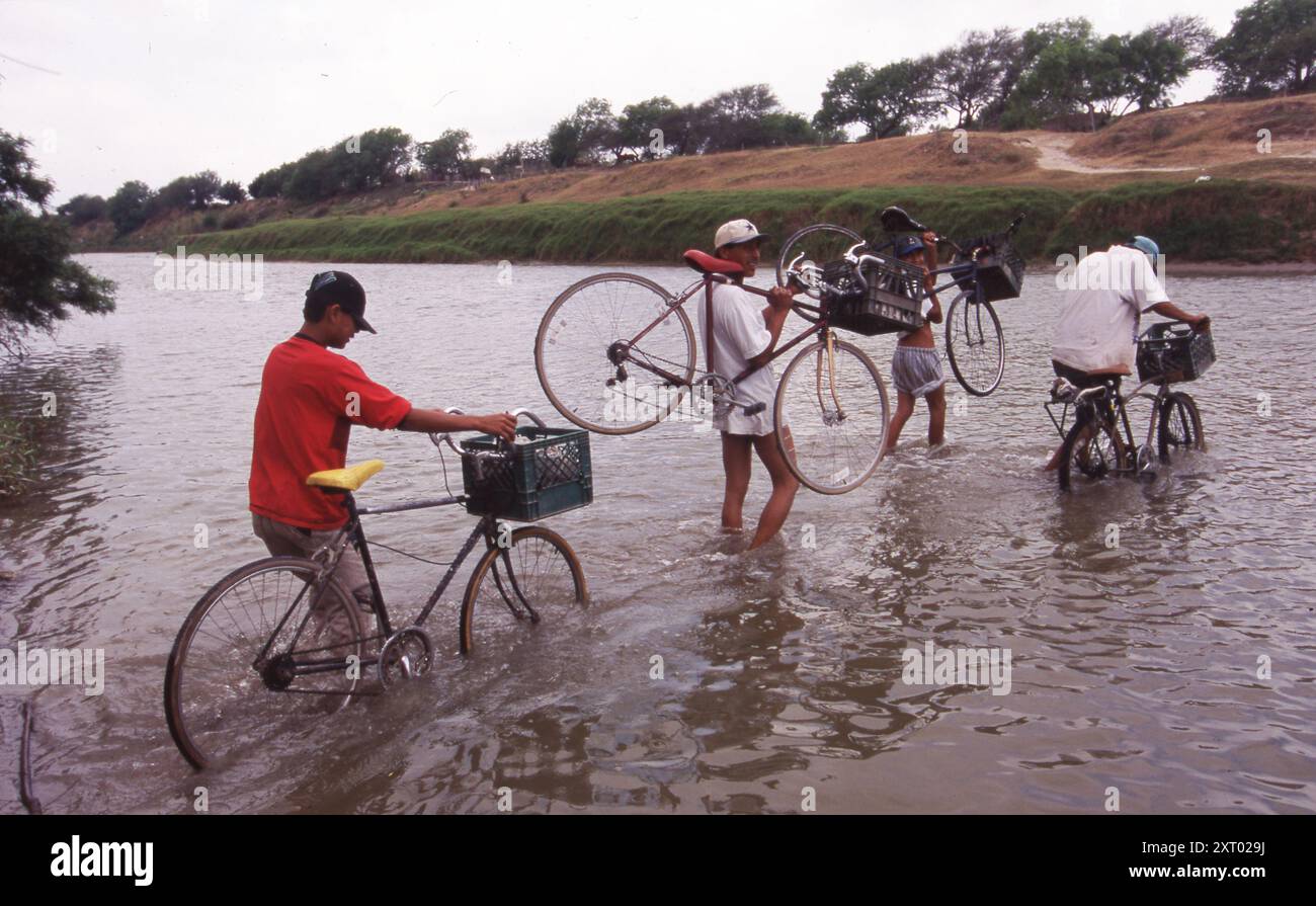 Laredo Texas USA, 1990: Mexican citizens with bicycles wade across a ...