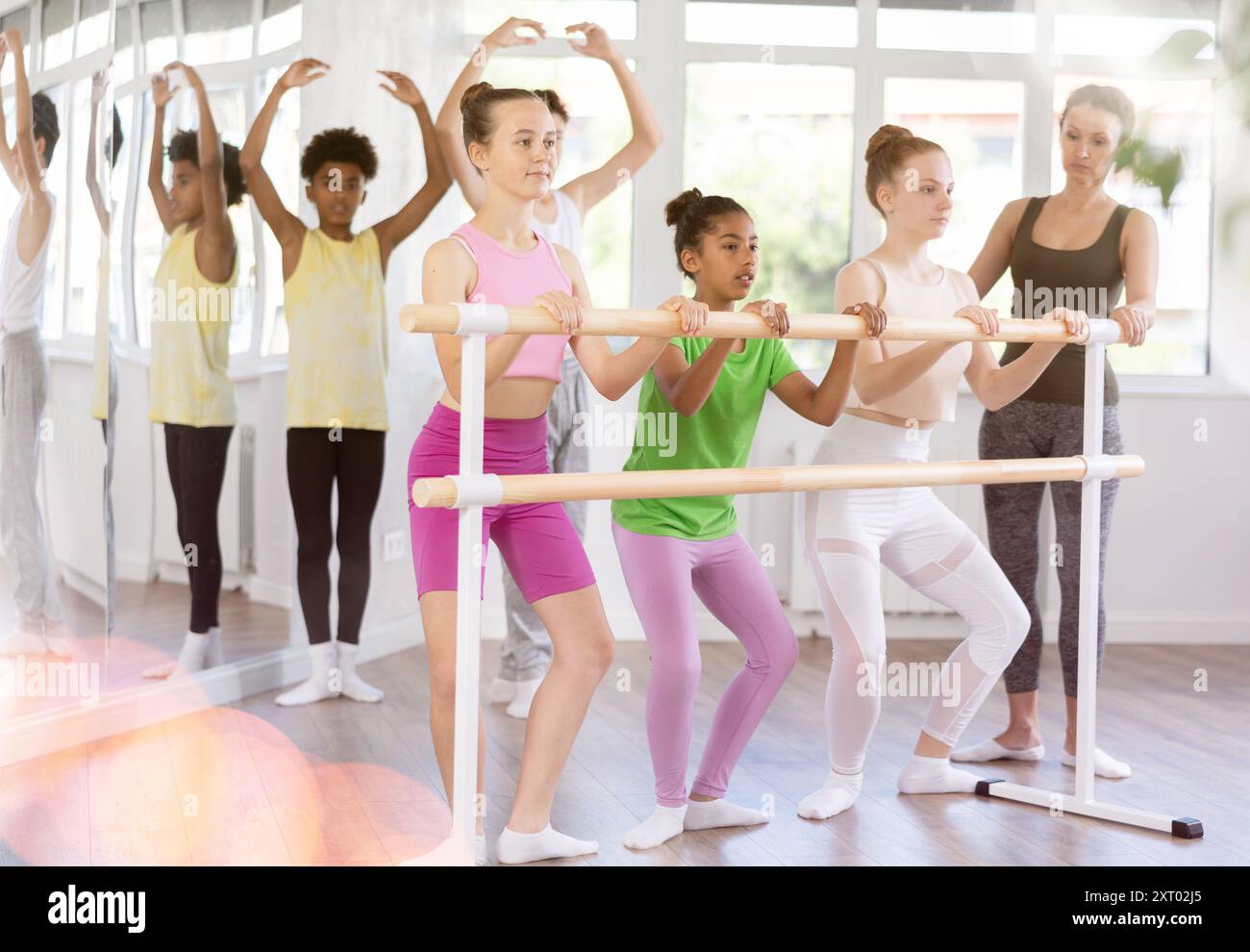 Teenage girls practicing demi plie at barre at ballet lesson Stock ...