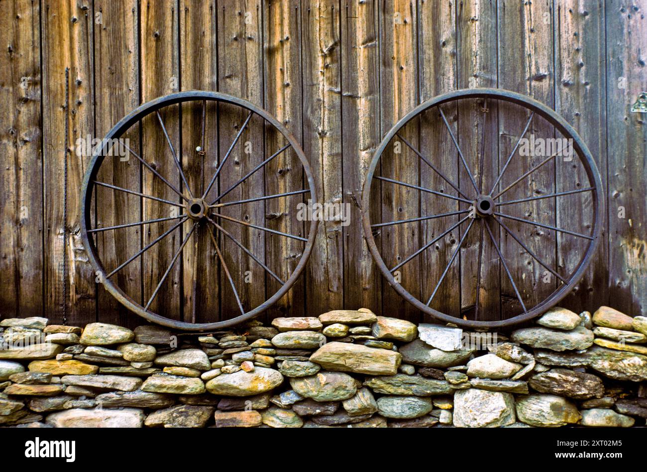 Vermont barn with rock wall and two antique wheels- lines and texture, New England Stock Photo ...