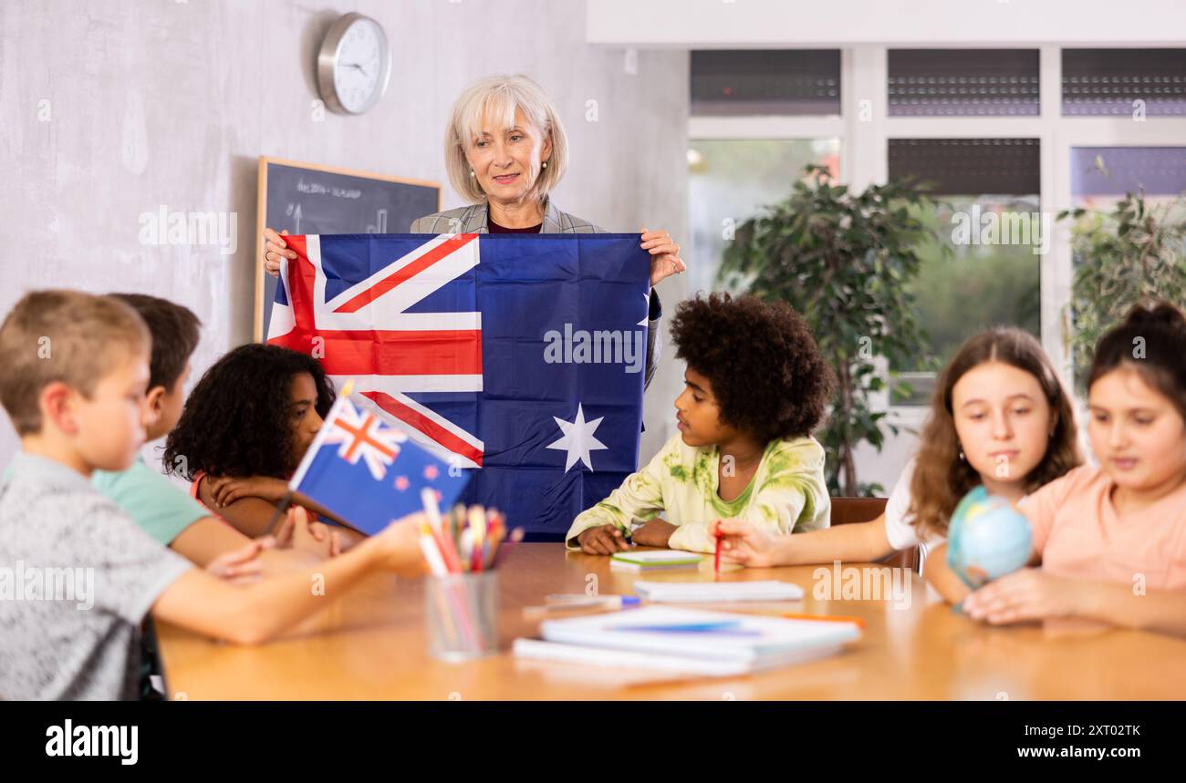 Female teacher showing australian flag to kids in geography class Stock ...