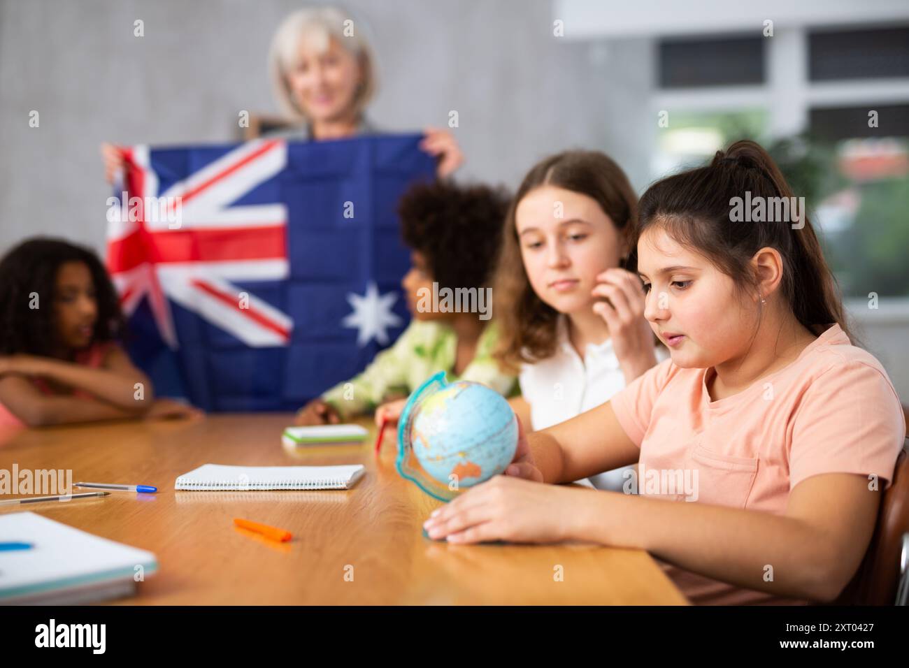 Female teacher showing australian flag to kids in geography class Stock ...