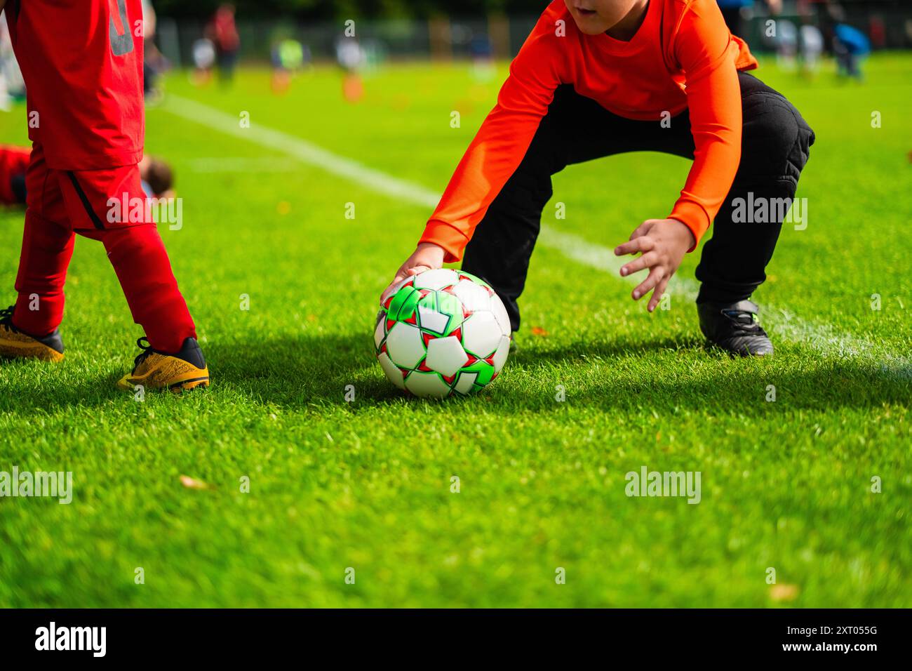 Football Goal Keeper in Orange Jersey Grabbing the Soccer ball with the ...