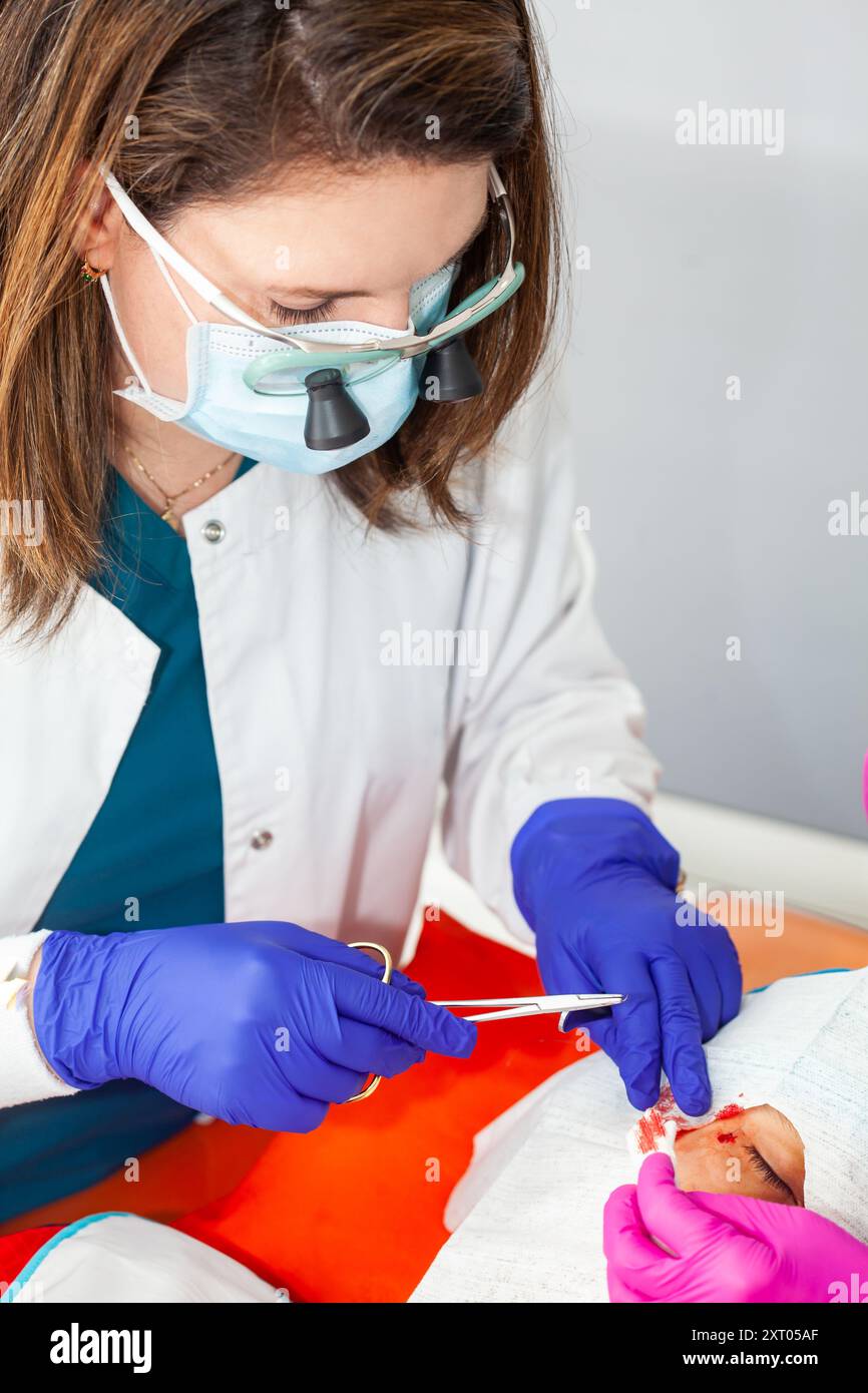 Doctor suturing a patient during a small surgery. Dermatologist ...