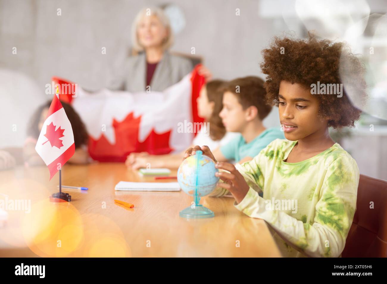 Female teacher showing canadian flag to kids in geography class Stock ...