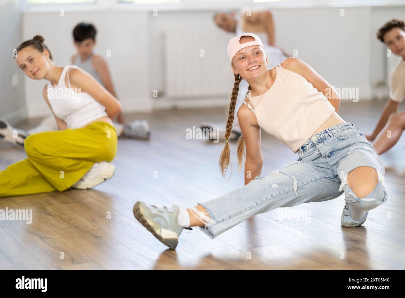 Girl in baseball cap with two hair pigtails with group of teenage ...