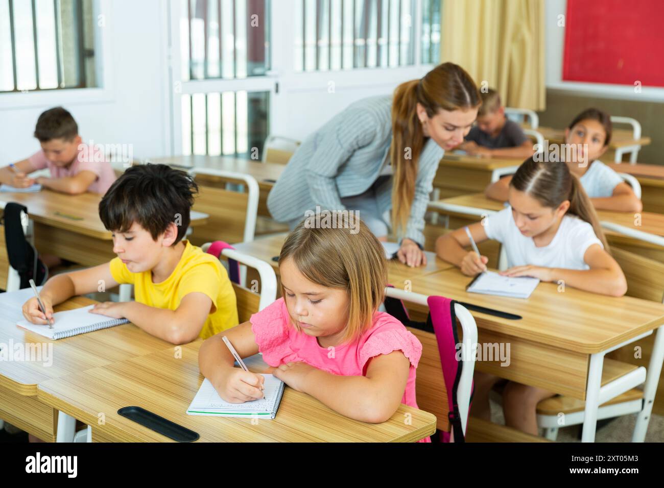 Group of school kids and teacher during lesson in classroom Stock Photo ...