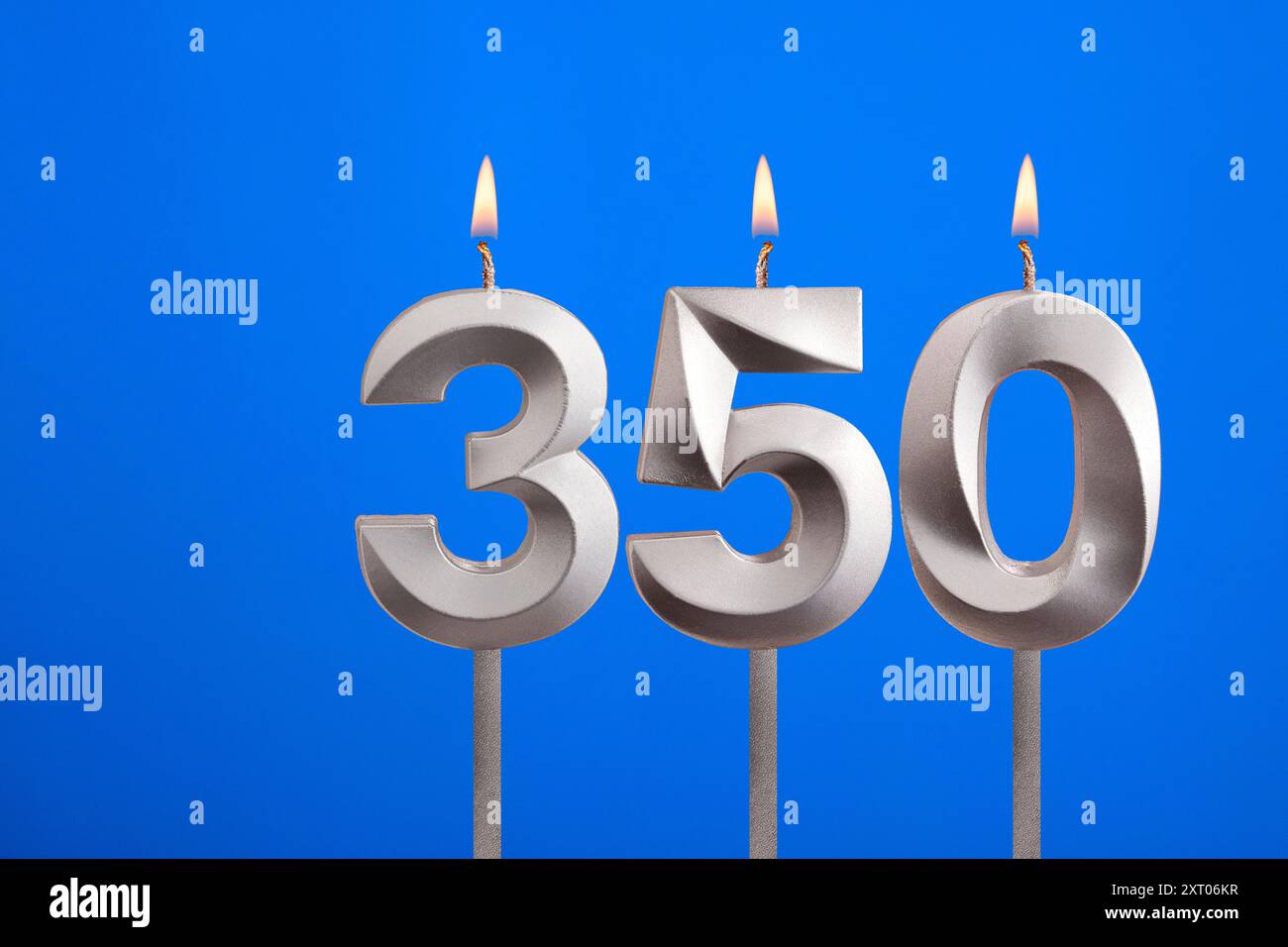 Birthday number 350 - Candle lit on blue background Stock Photo - Alamy