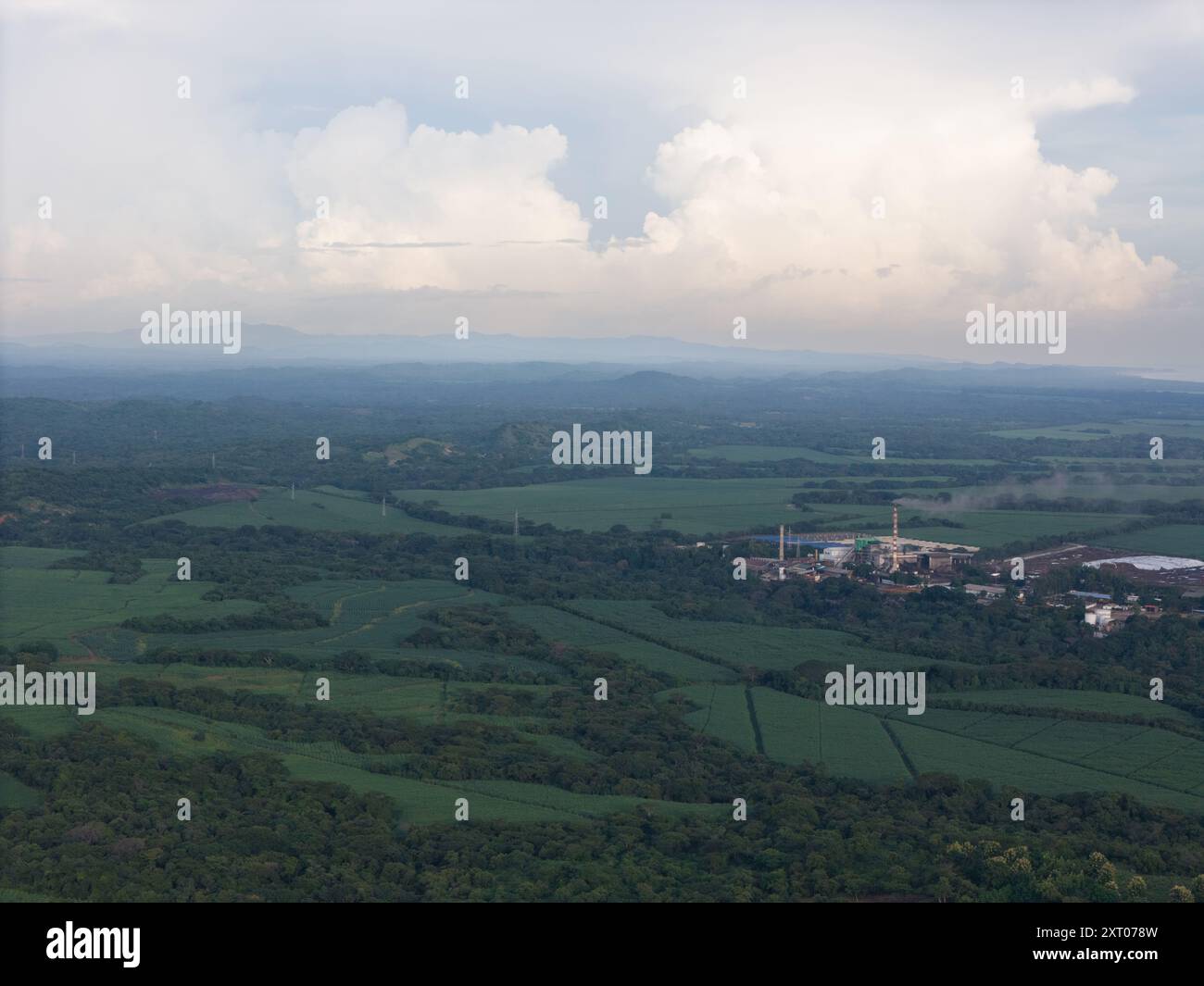 Big factory with tall smokey chimney on green landscape aerial drone ...