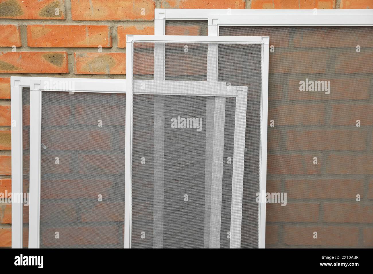 Set of window screens near brick wall Stock Photo - Alamy