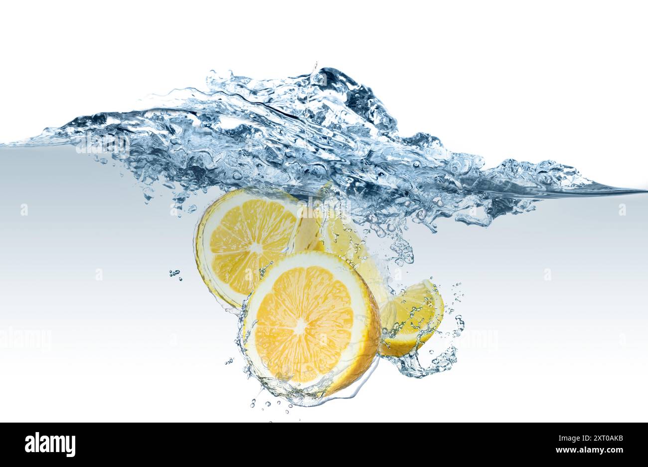 Fresh lemons falling into water on white background Stock Photo - Alamy