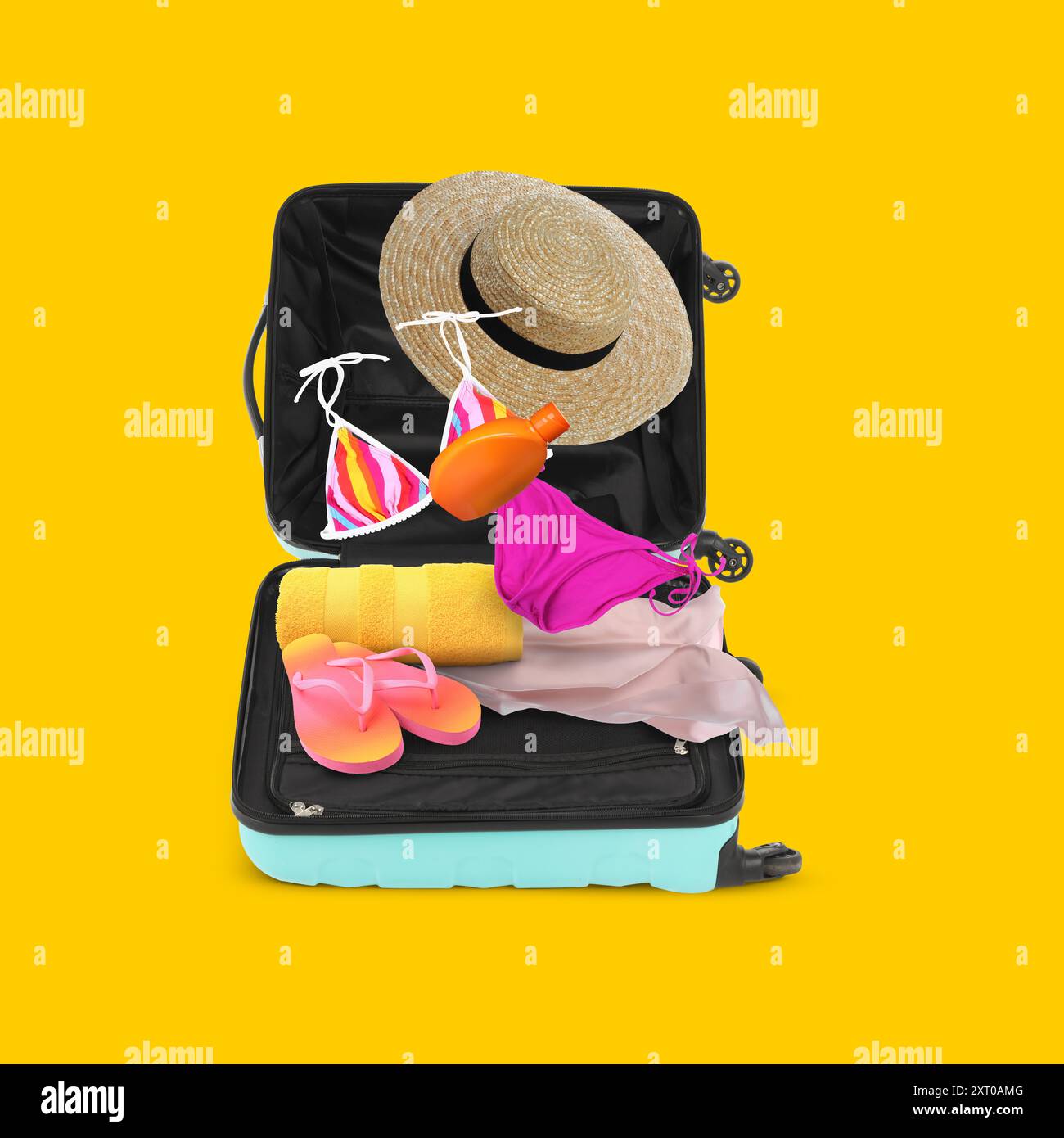 Different beach stuff falling into suitcase on golden background Stock ...