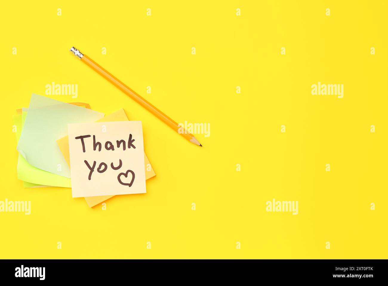 Sticky note with text THANK YOU, drawn heart and pencil on yellow ...