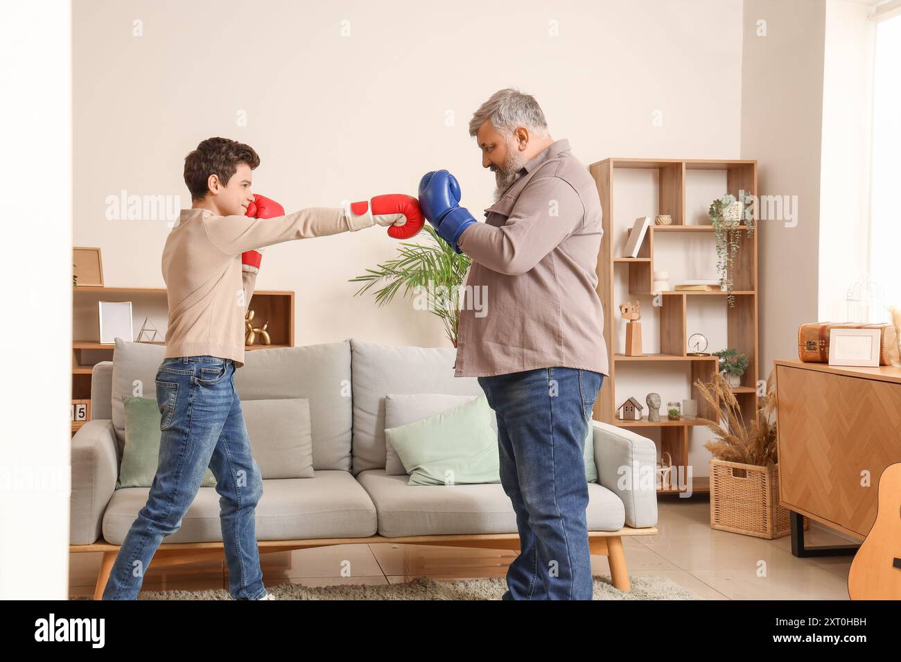 Happy grandfather and his cute grandson during boxing training at home ...