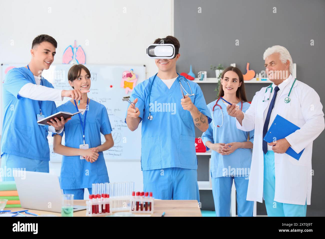Male medical student with surgical instruments using VR glasses at ...