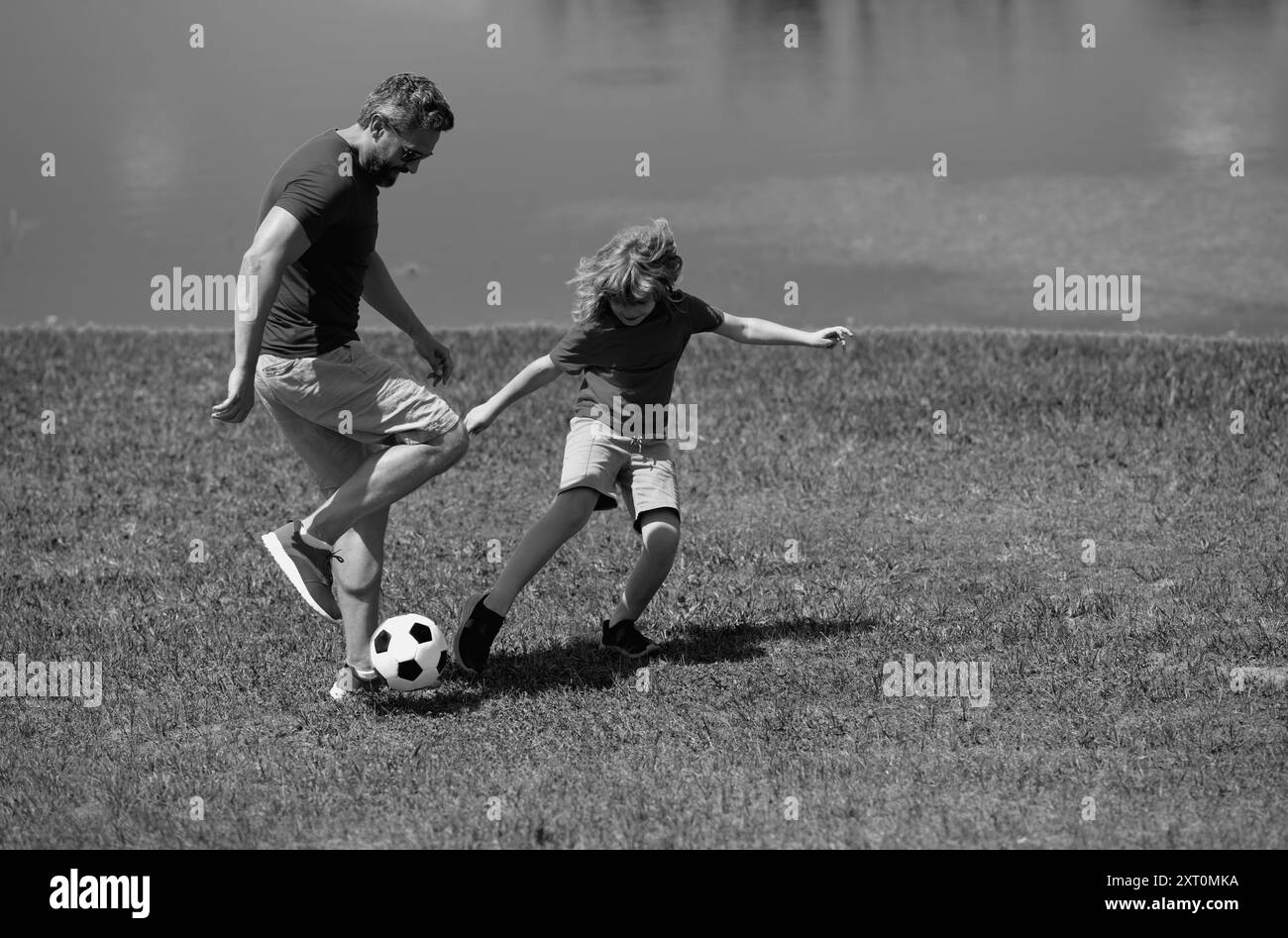 Father and son enjoy a friendly game of football. Practice passing and ...