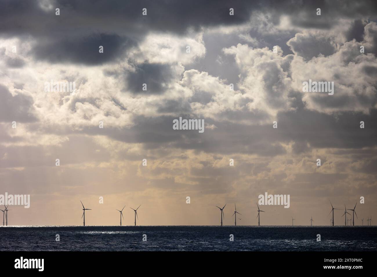 Dark clouds of a thunderstorm over silhouettes of wind turbines in the ...