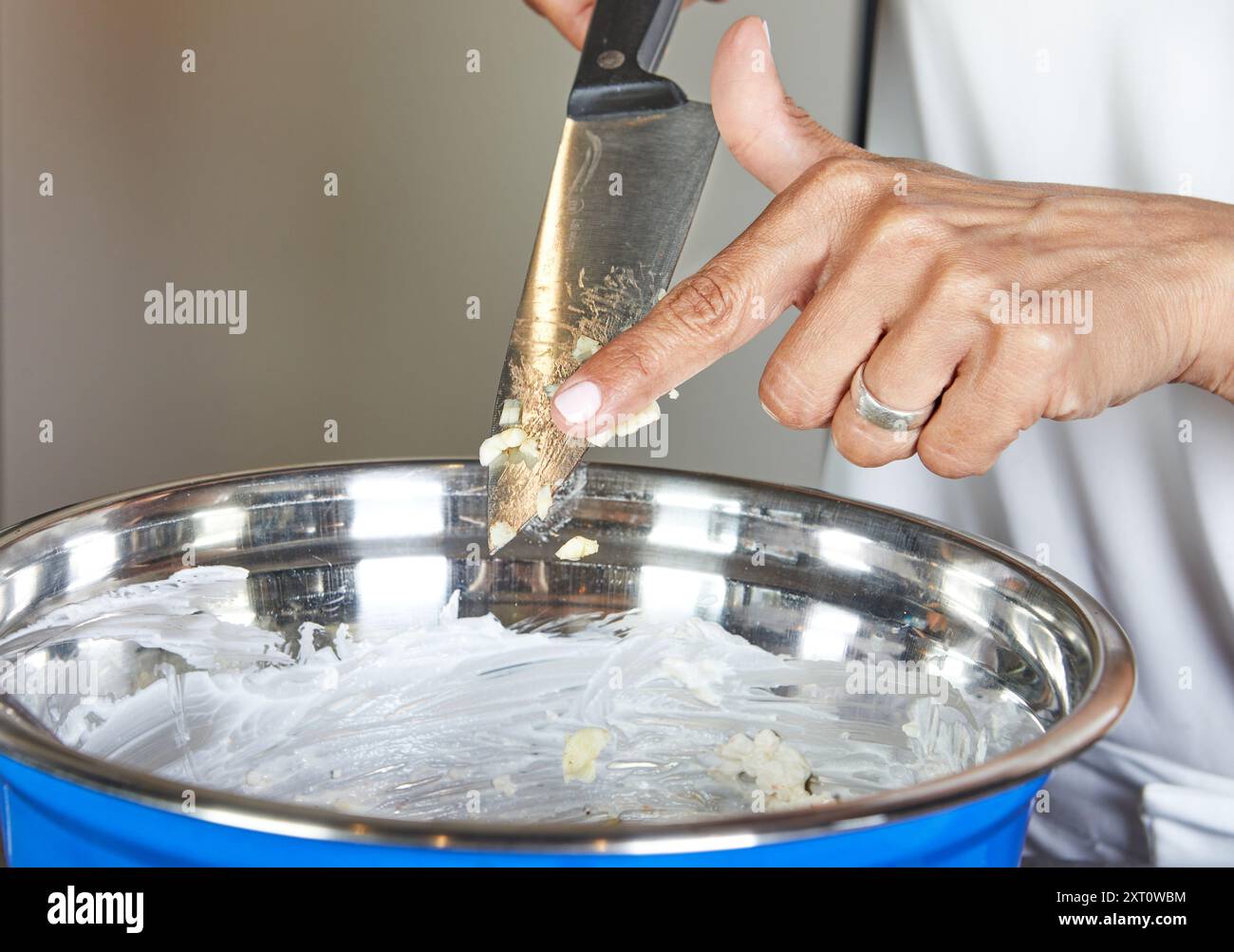 Close up of hands adding spices to a bowl, highlighting the process of ...